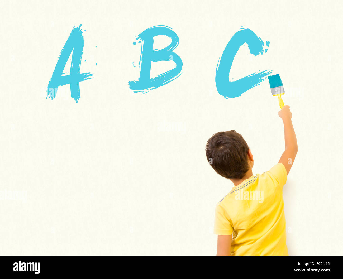 Little boy painting ABC with brush on the wall Stock Photo - Alamy