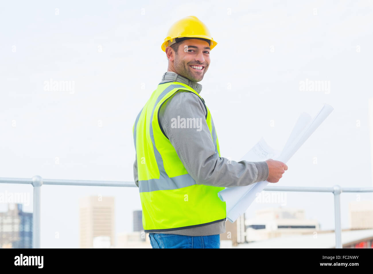 Architect in protective clothing holding blueprint outdoors Stock Photo ...