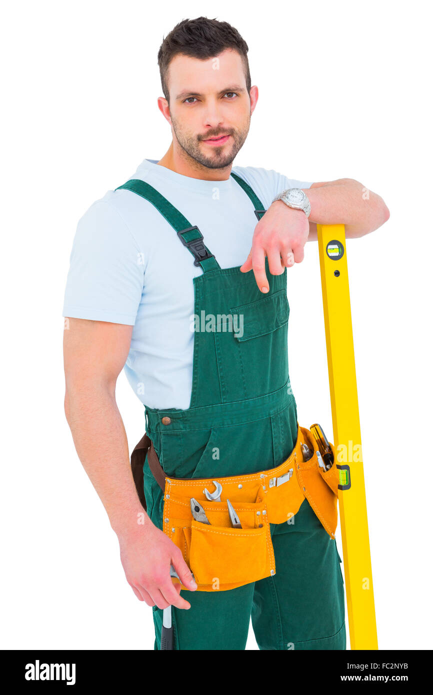 Carpenter smiling to camera with spirit level Stock Photo - Alamy