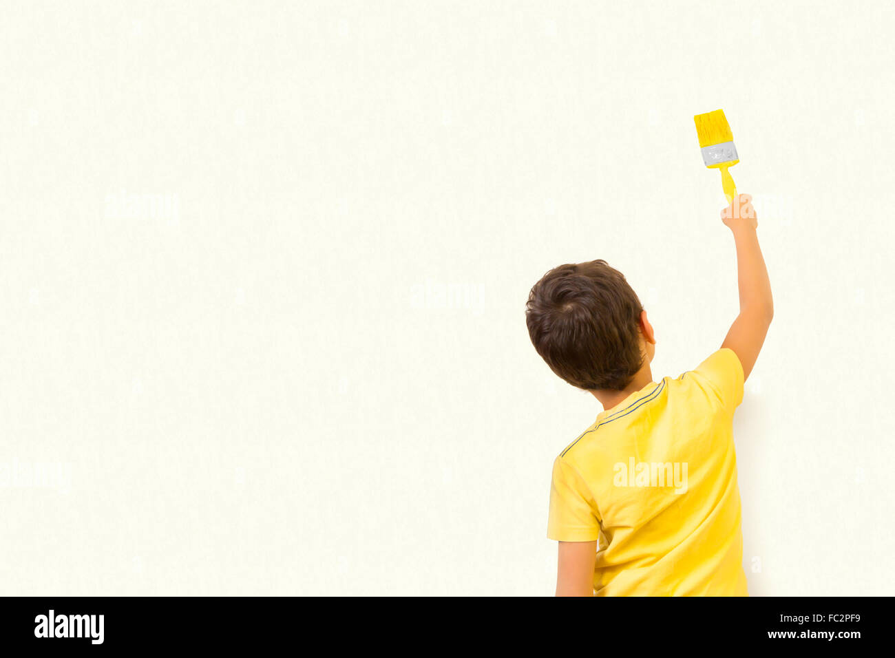 Little boy drawing something on wall background Stock Photo - Alamy