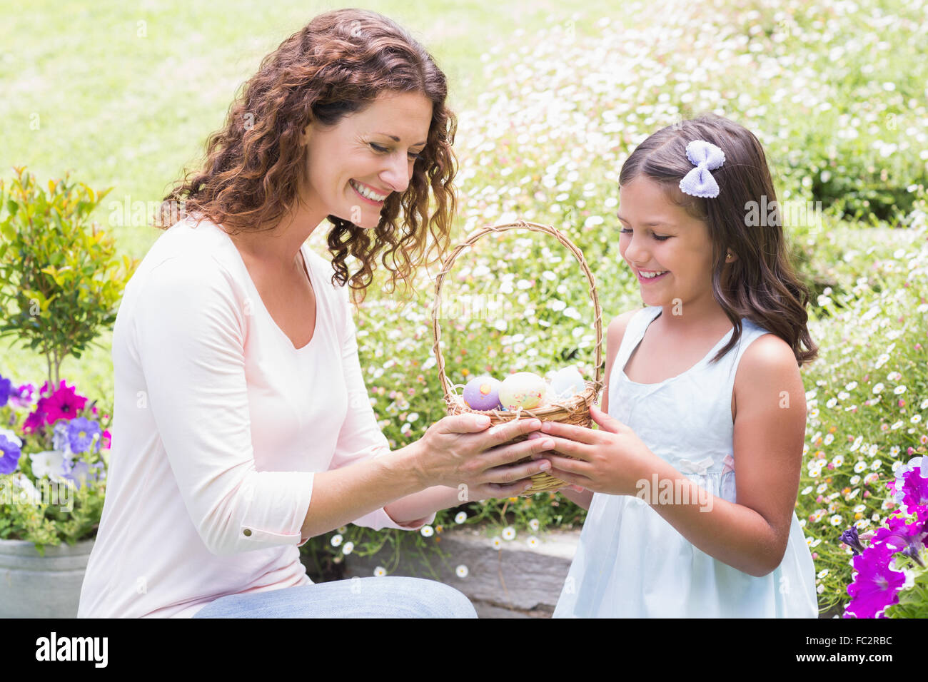 Happy mother and daughter collecting easter eggs Stock Photo - Alamy