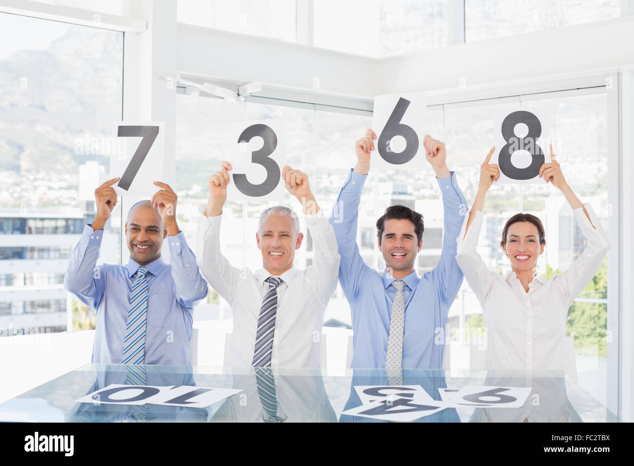 Smiling business team showing paper with rating Stock Photo - Alamy
