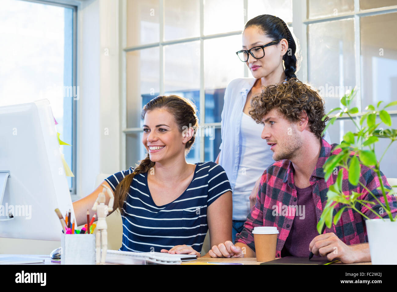 Smiling partners working together on computer Stock Photo - Alamy
