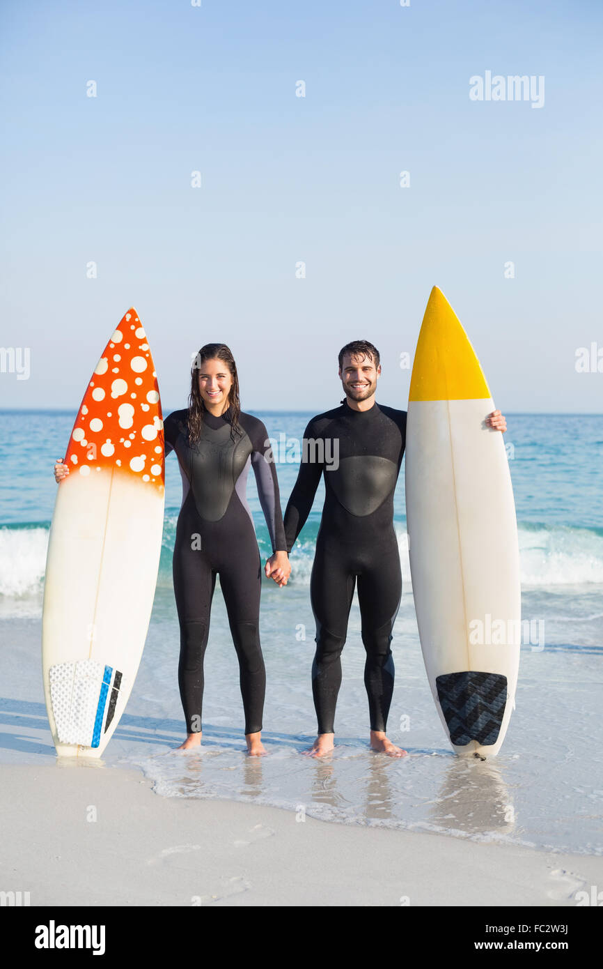Surfer couple holding hands hi-res stock photography and images - Alamy