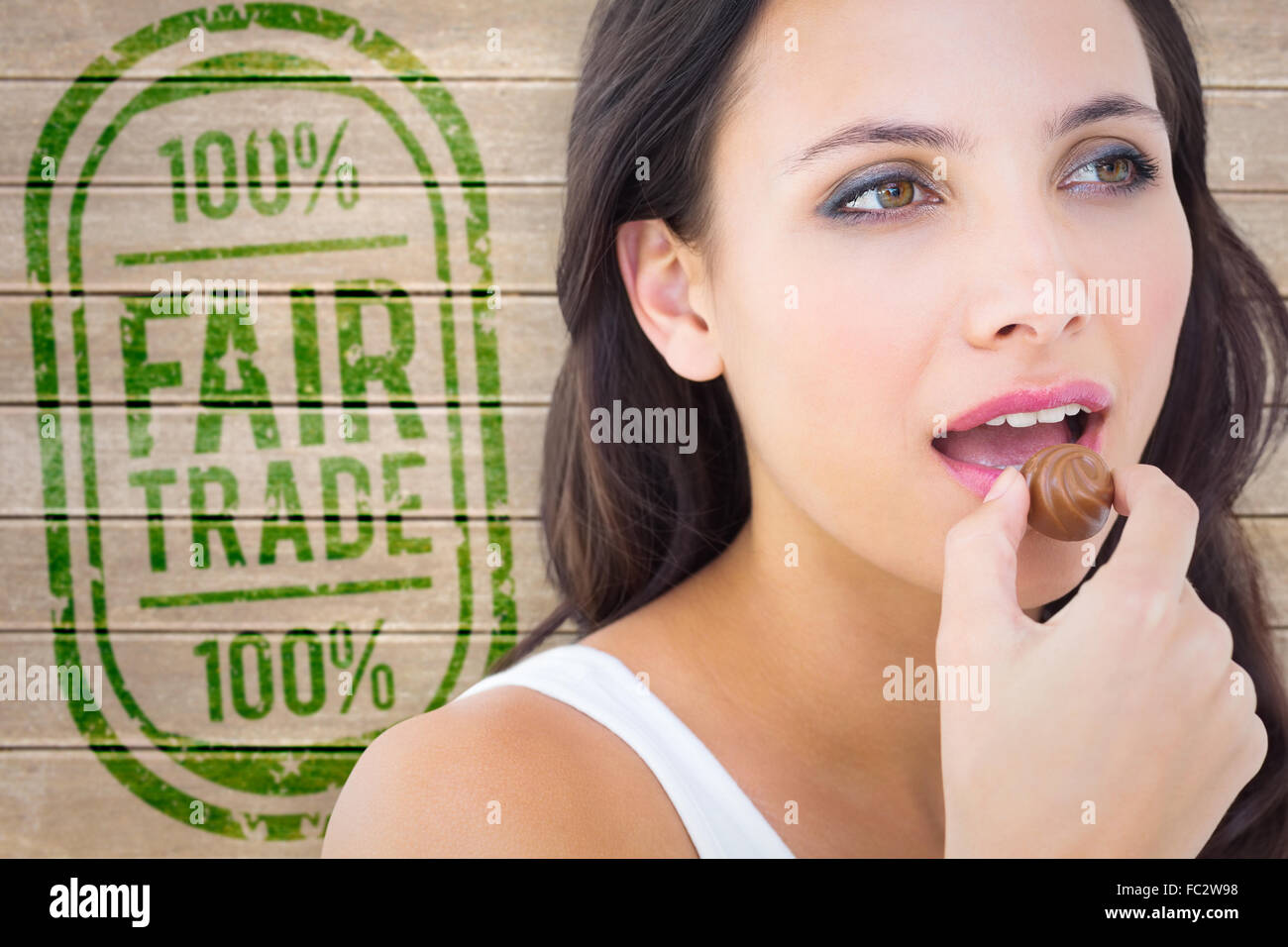 Composite image of pretty brunette eating chocolate candy Stock Photo ...