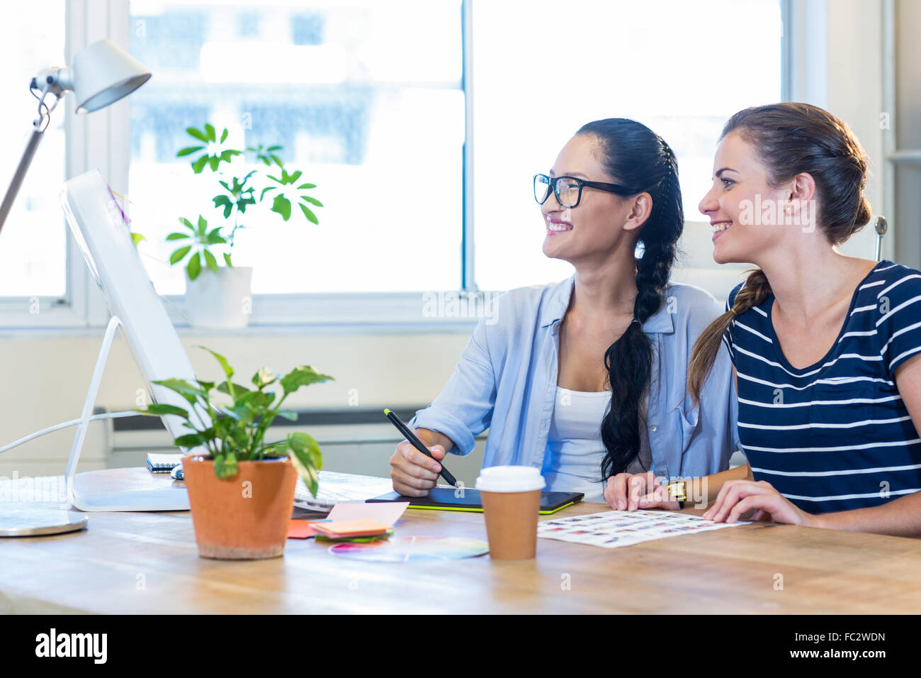 Smiling partners working together on computer and digitizer Stock Photo ...