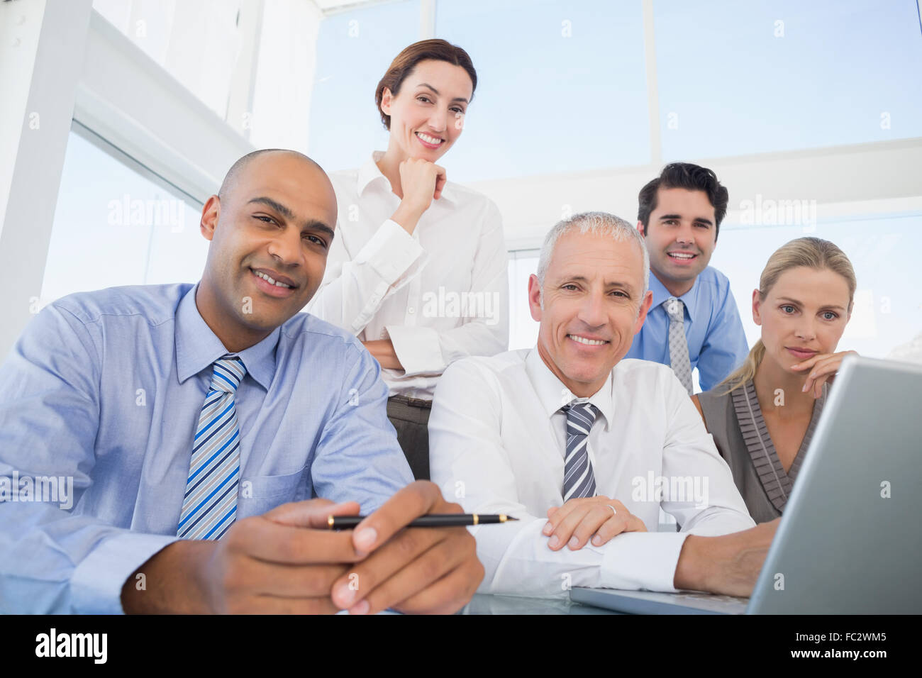 Business team during meeting smiling at camera Stock Photo - Alamy