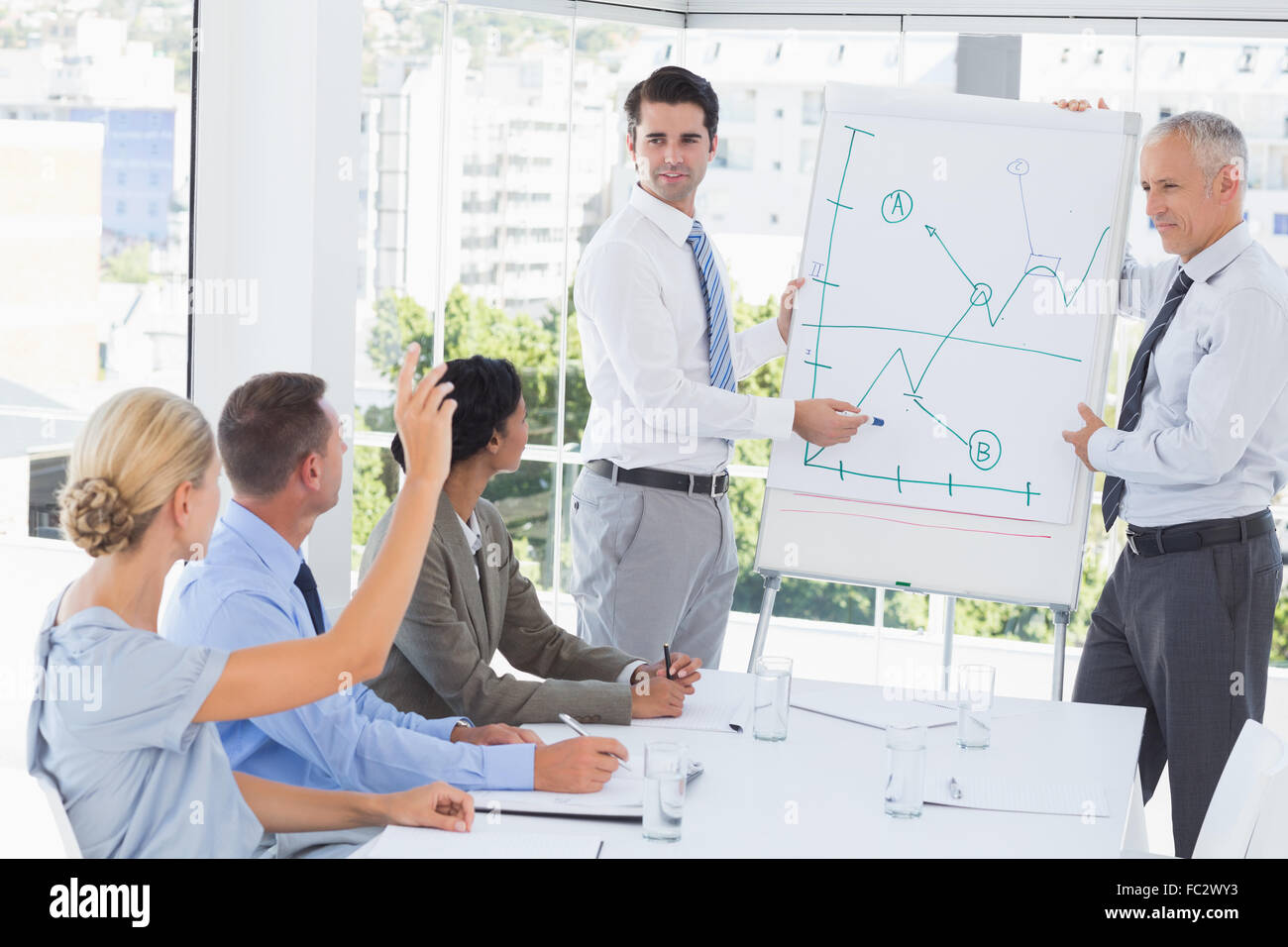 Businessman explaining the graph on the whiteboard Stock Photo - Alamy