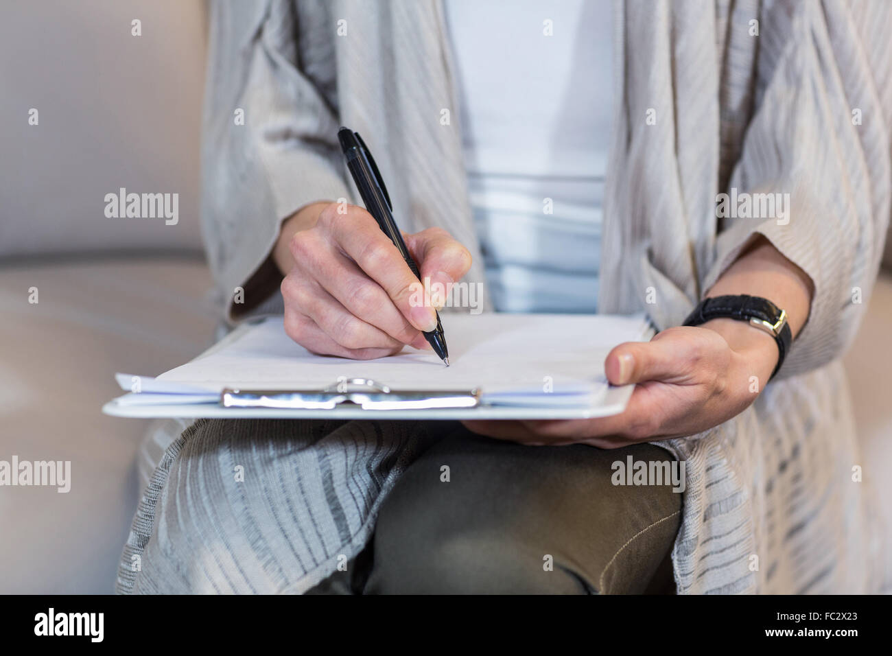 Psychologist sitting on the couch and taking notes Stock Photo - Alamy