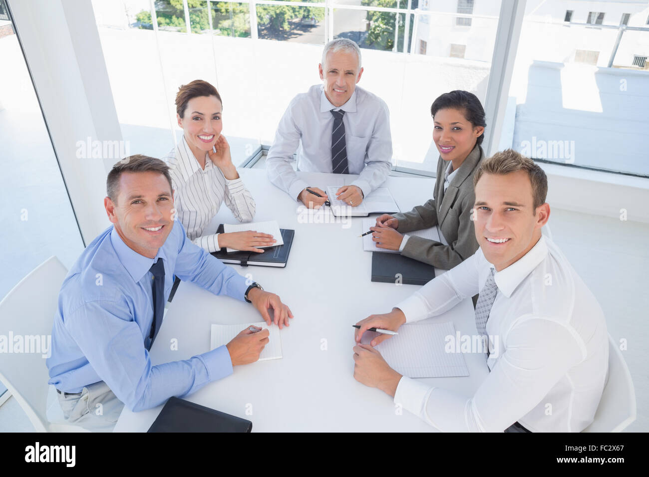 Business team sitting together around the table Stock Photo - Alamy