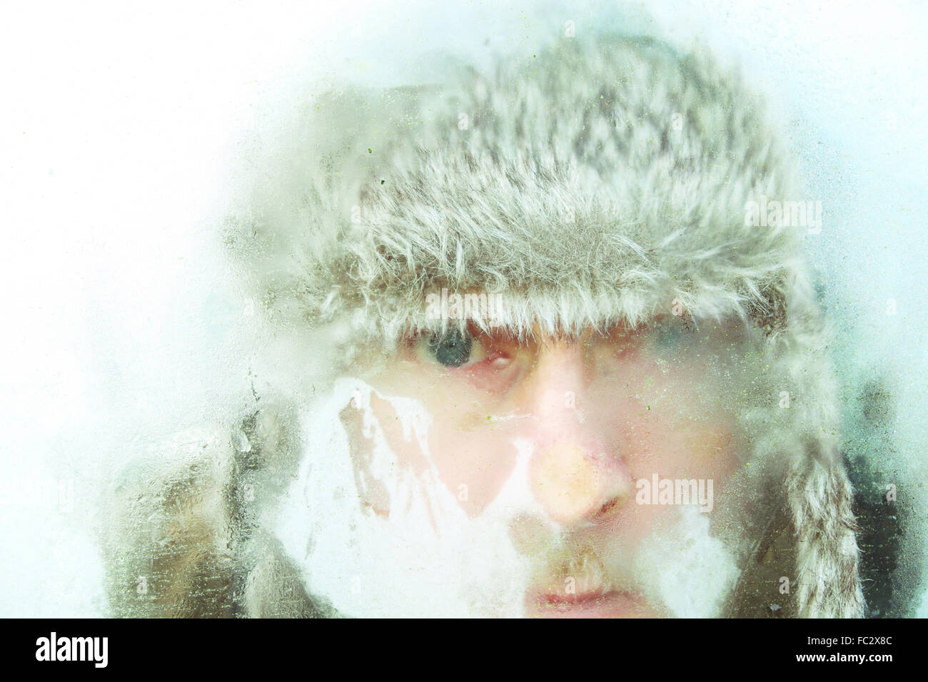 Cold man with fur hat outside a frozen window in winter fog Stock Photo ...