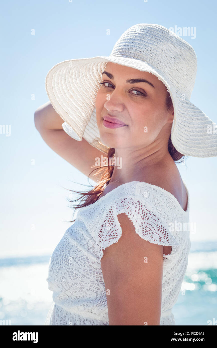 Pretty brunette wearing sunhat and looking at camera Stock Photo - Alamy
