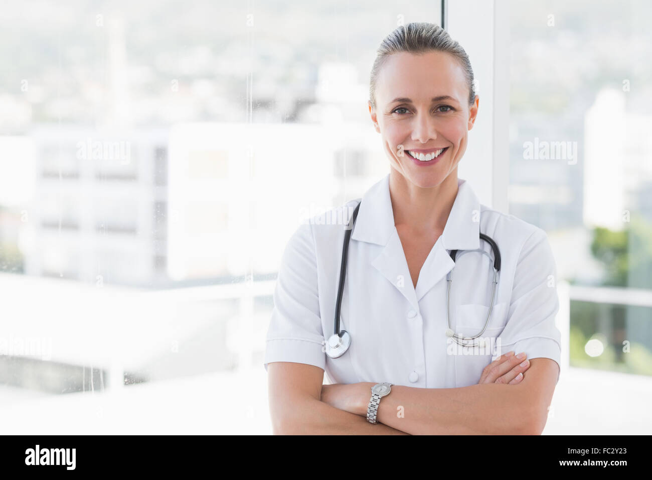 happy doctor smiling at camera with arms crossed Stock Photo - Alamy