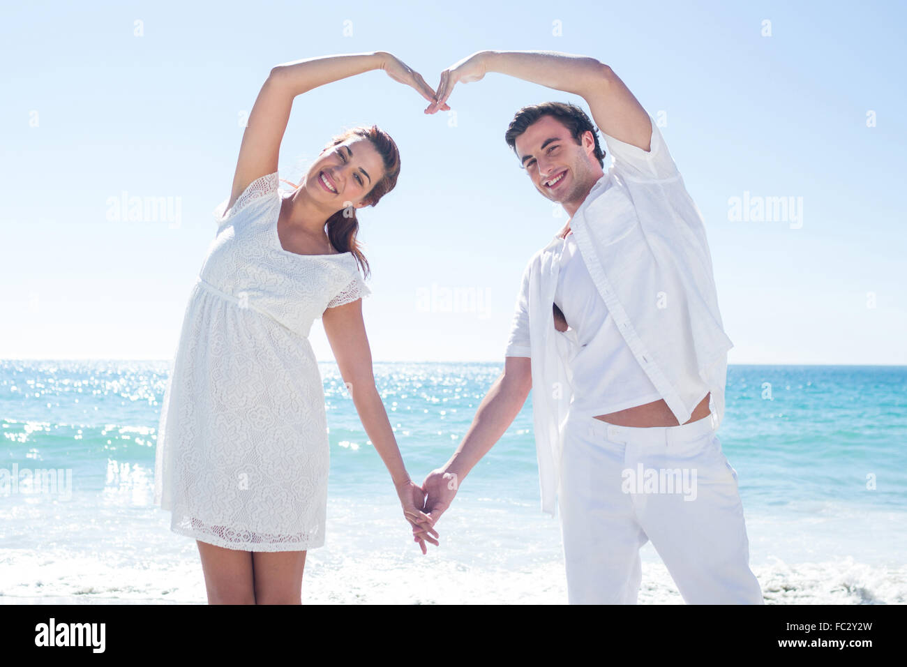 Happy couple forming heart shape with their hands Stock Photo - Alamy