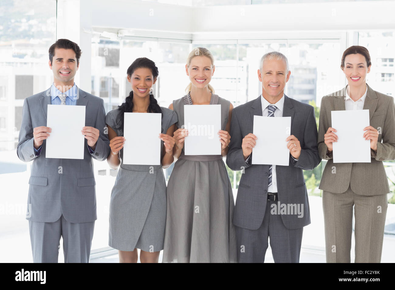 Business colleagues holding sheets of paper together Stock Photo - Alamy