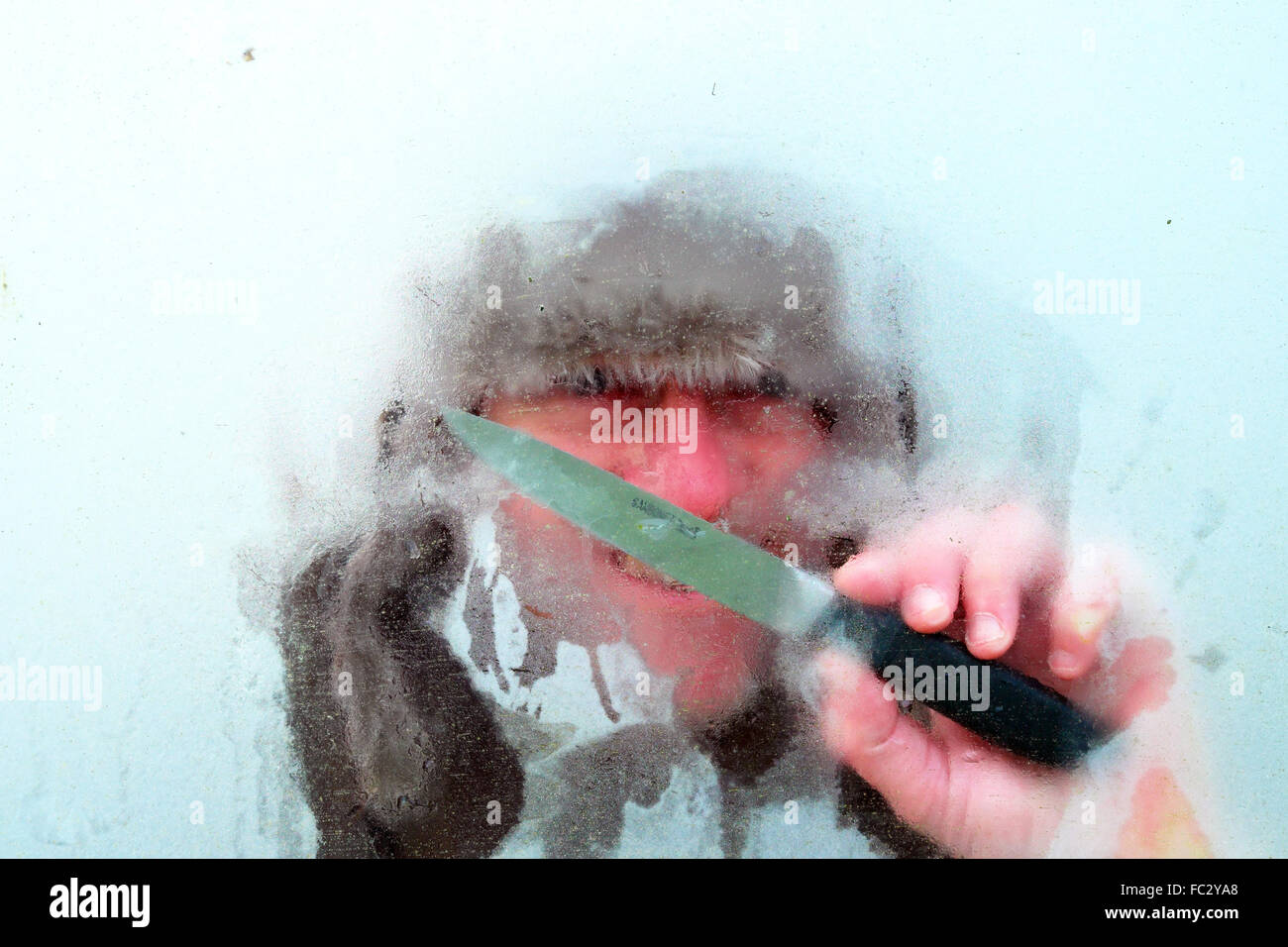 Scary man with knife looking through frosty frozen winter window Stock ...