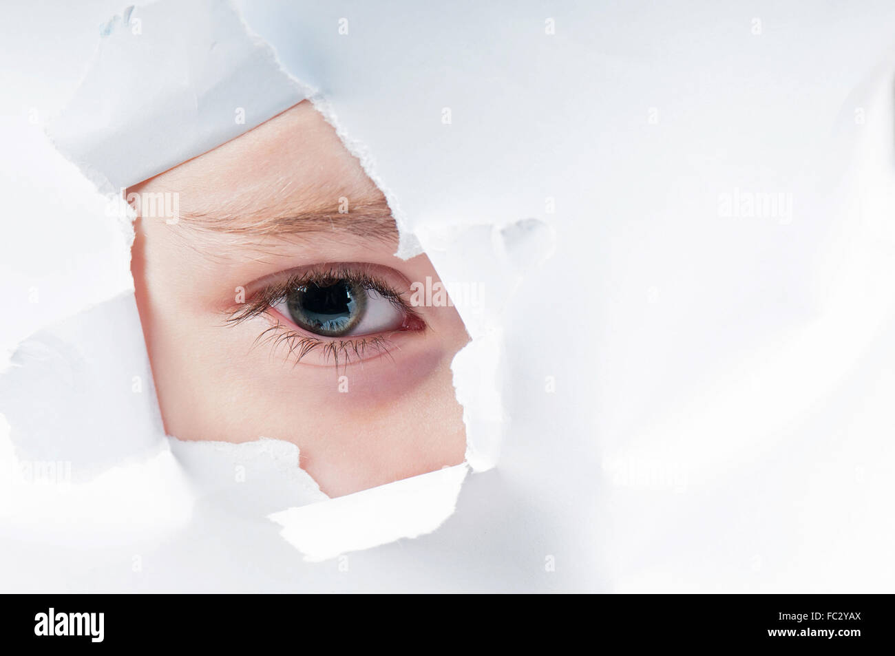 Cute baby girl looking through paper hole Stock Photo - Alamy
