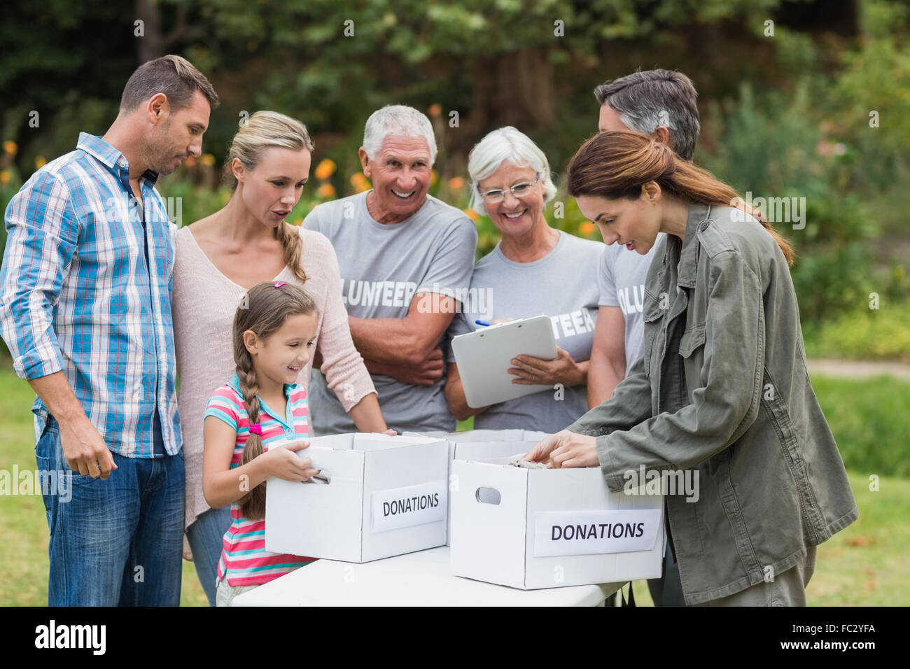Happy volunteer family separating donations stuffs Stock Photo - Alamy