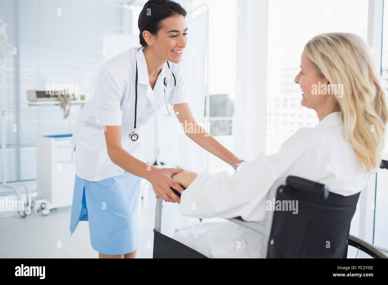 Happy doctor smiling at her patient in wheelchair Stock Photo - Alamy