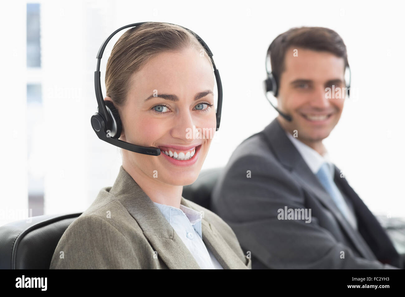 Business people with headsets smiling at camera Stock Photo - Alamy