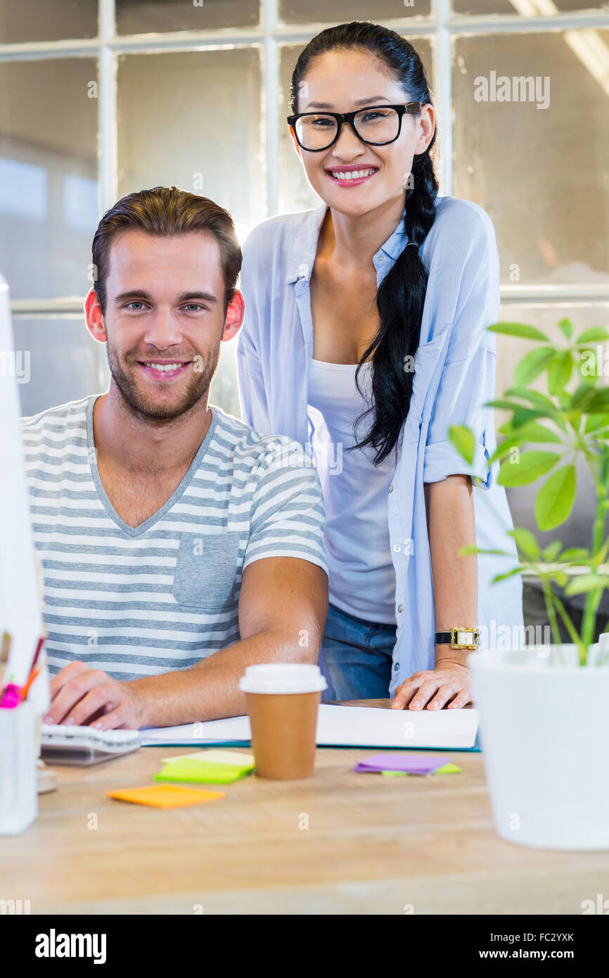 Smiling partners working together on computer Stock Photo - Alamy
