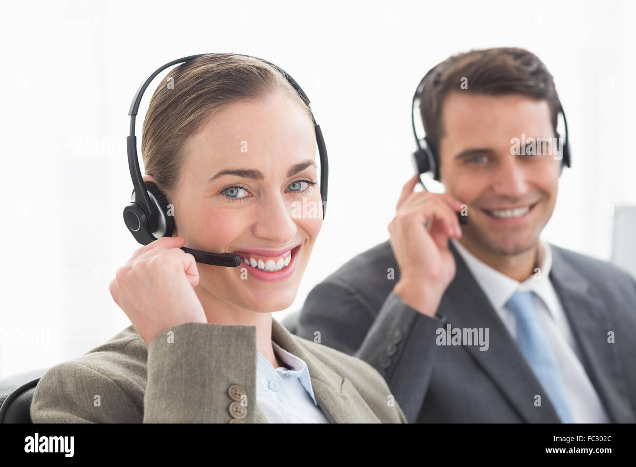 Business people with headsets smiling at camera Stock Photo - Alamy