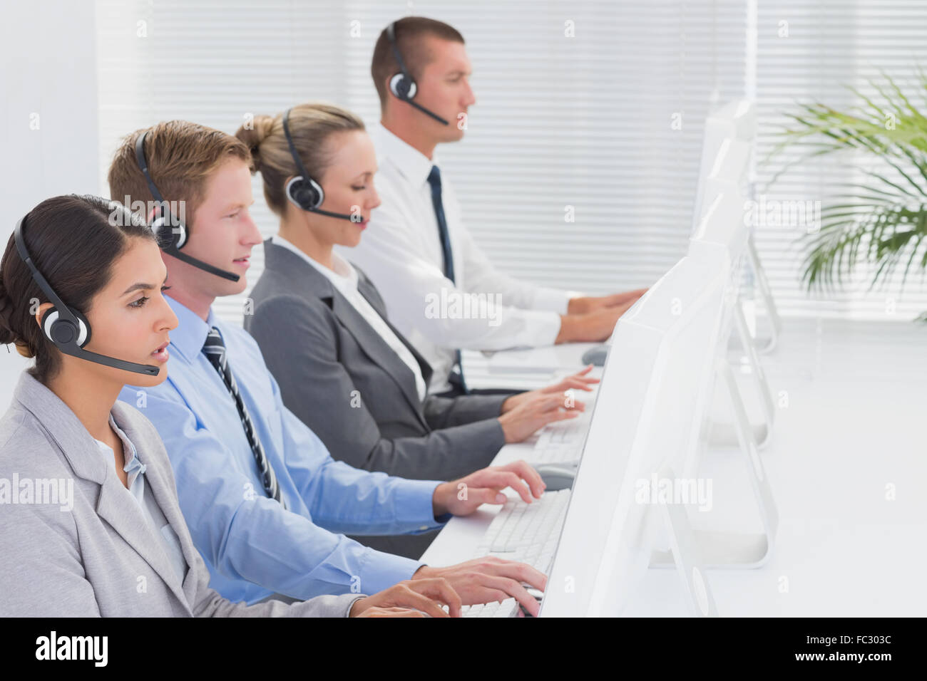 Business team working on computers and wearing headsets Stock Photo - Alamy