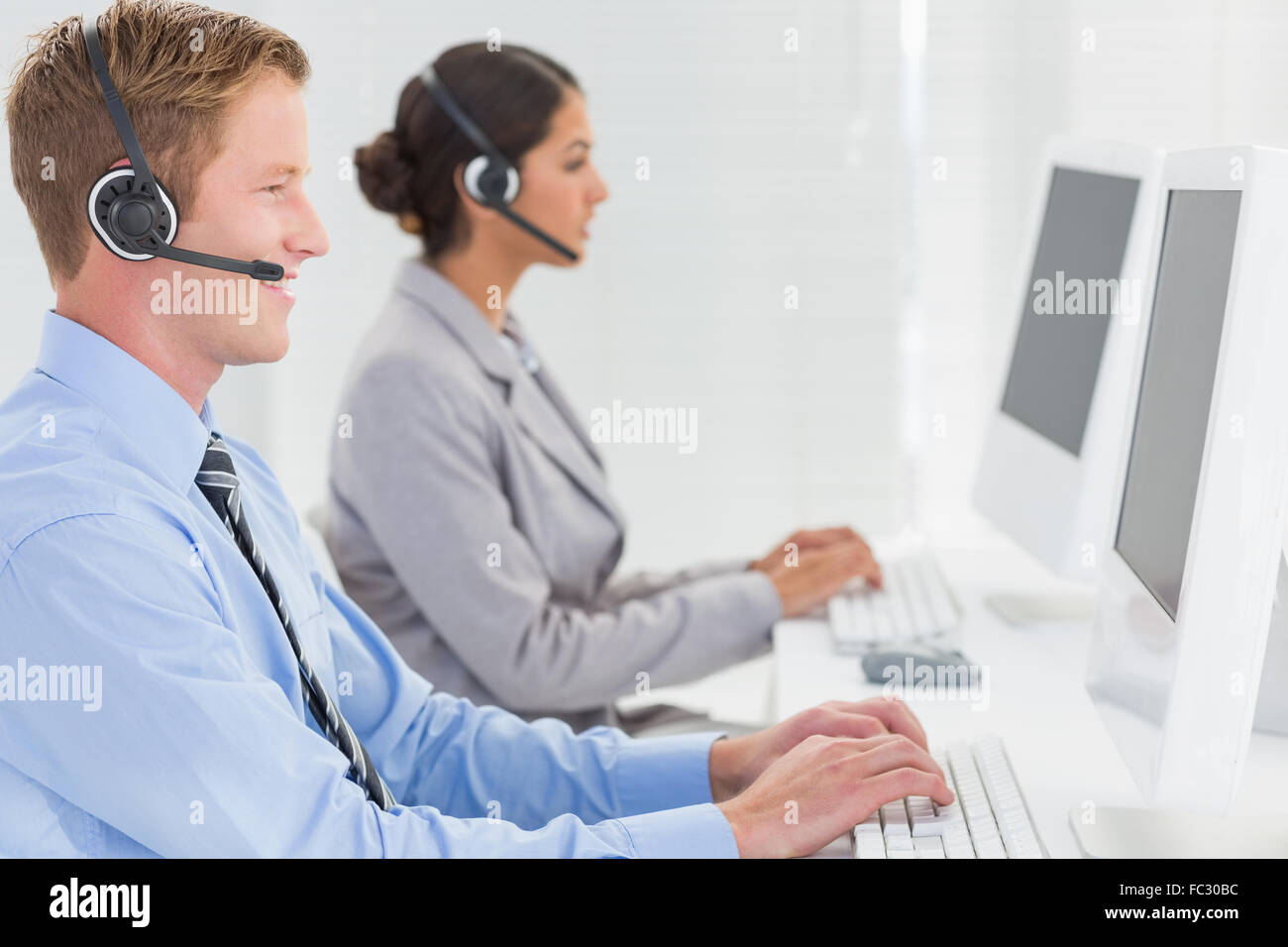 Business team working on computers and wearing headsets Stock Photo - Alamy