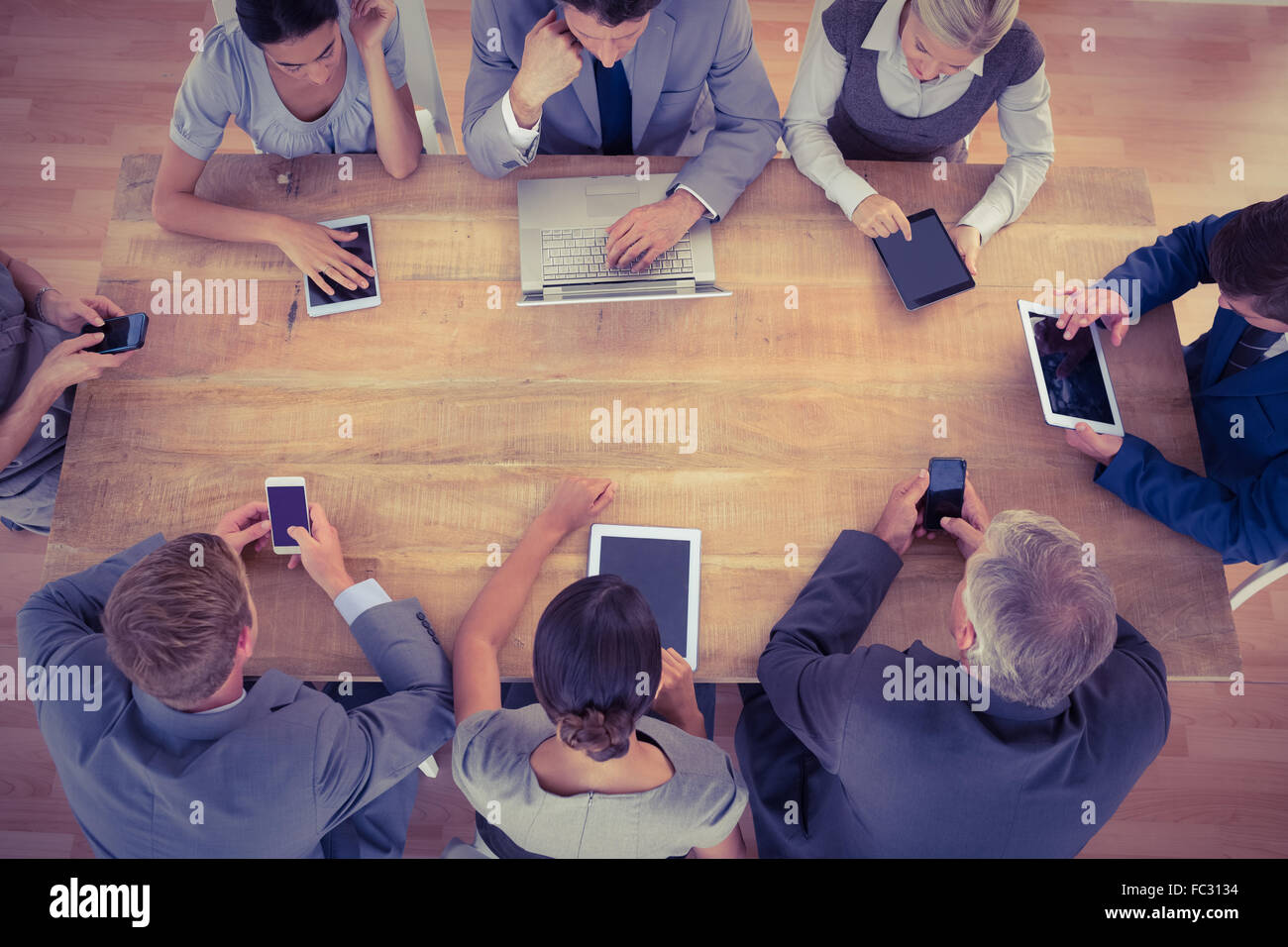Business team working on their multimedia devices Stock Photo - Alamy