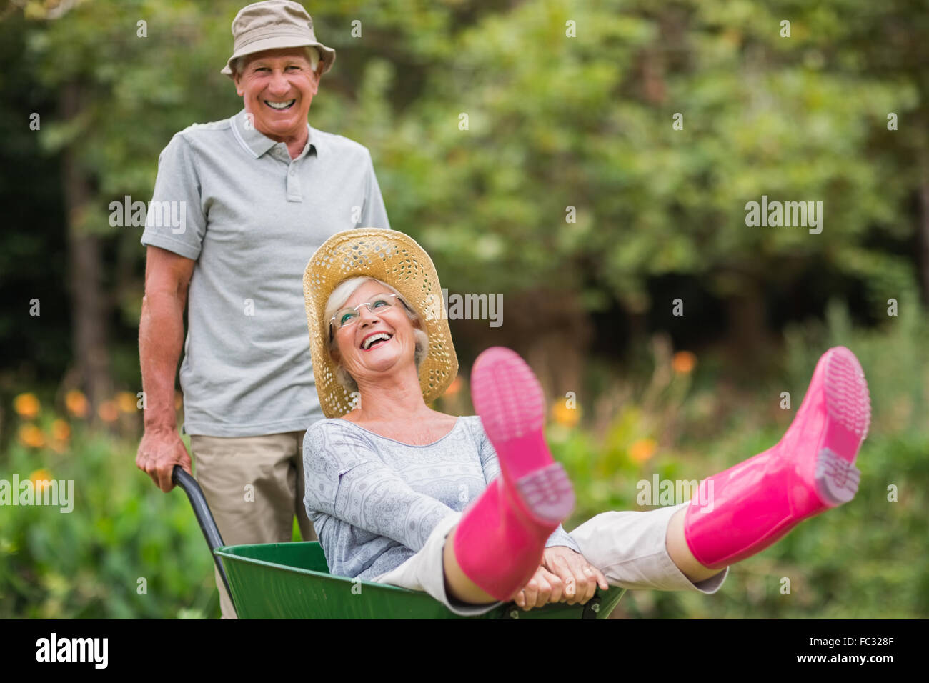 Happy senior couple playing with a wheelbarrow Stock Photo - Alamy