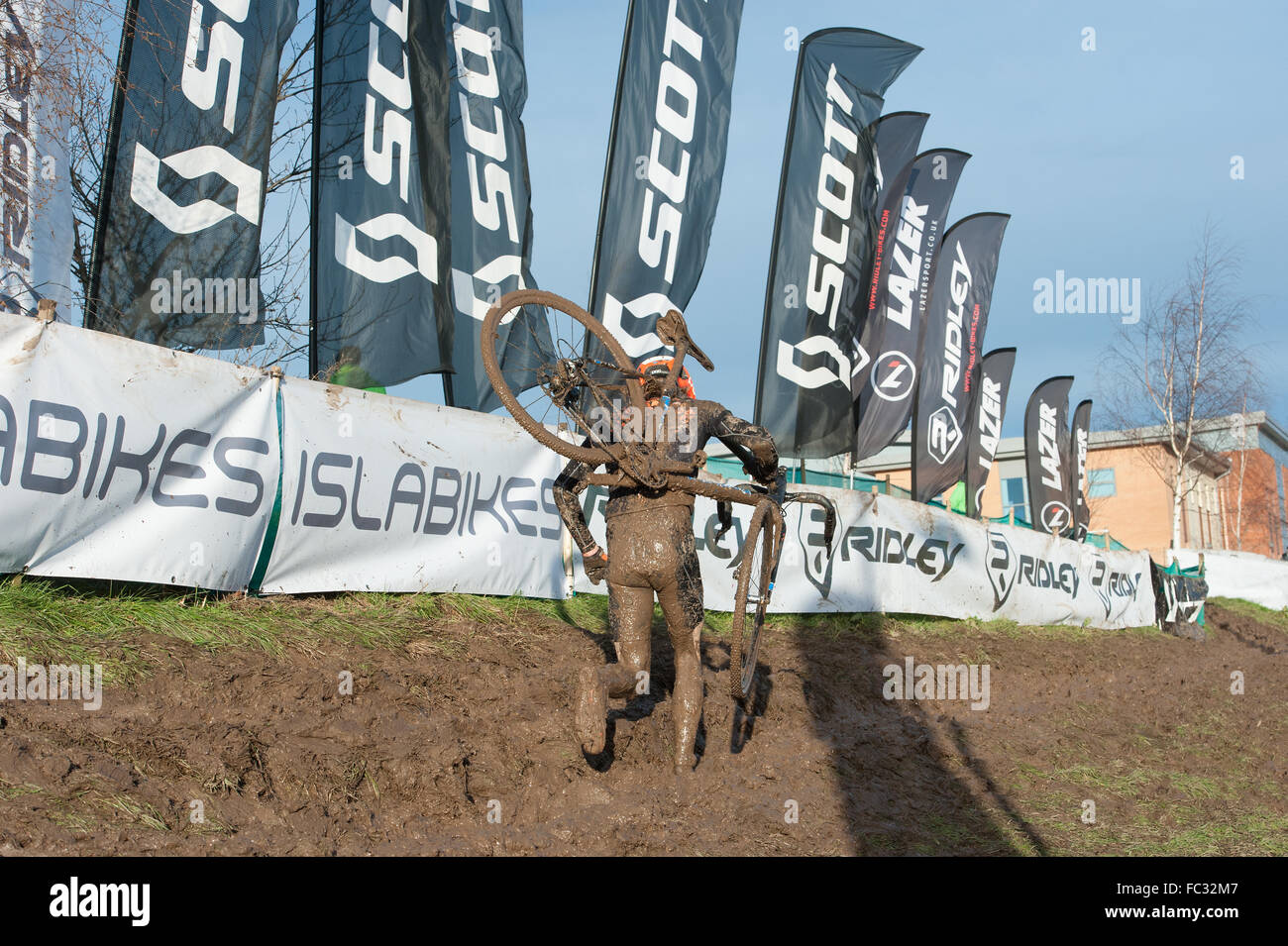 Cyclocross rider running through the mud & carriyng his bike during a ...