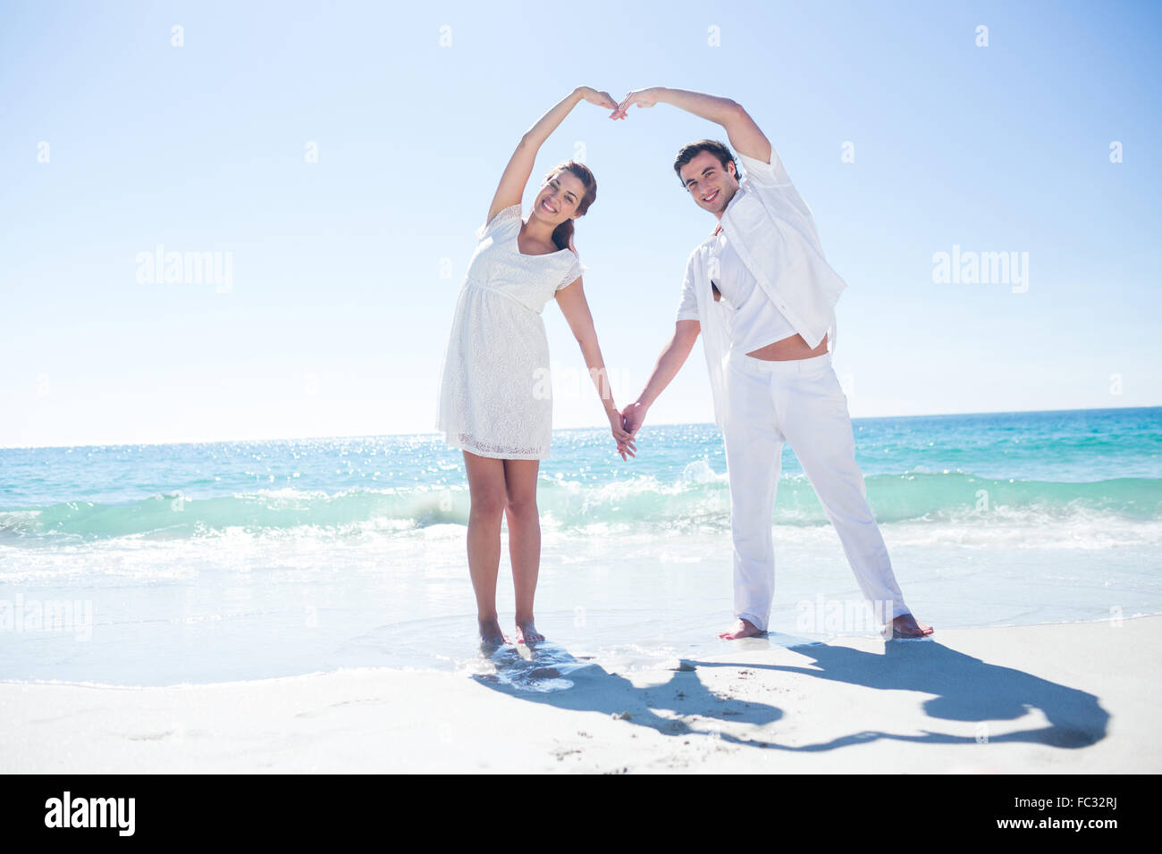 Happy couple forming heart shape with their hands Stock Photo - Alamy