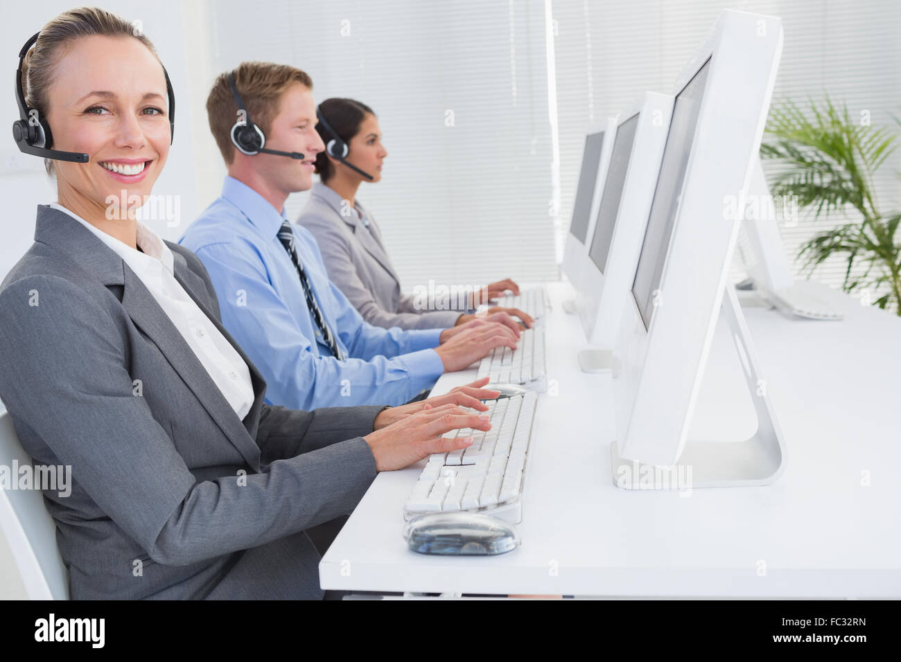 Business team working on computers and wearing headsets Stock Photo - Alamy