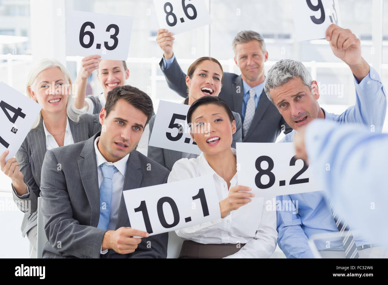 Interview panel holding score cards in office Stock Photo - Alamy
