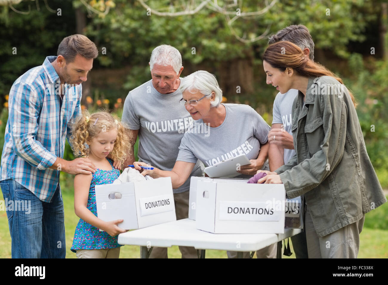 Happy volunteer family separating donations stuffs Stock Photo - Alamy
