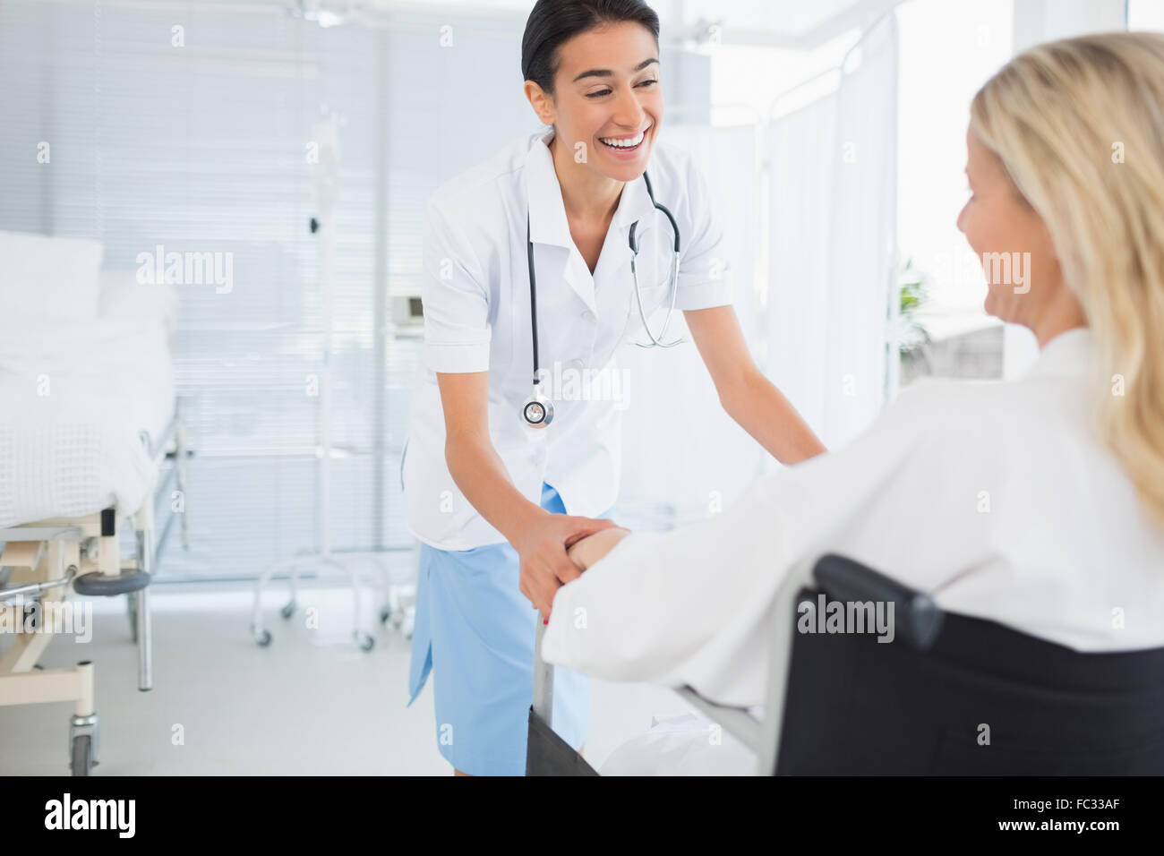Happy doctor smiling at her patient in wheelchair Stock Photo - Alamy