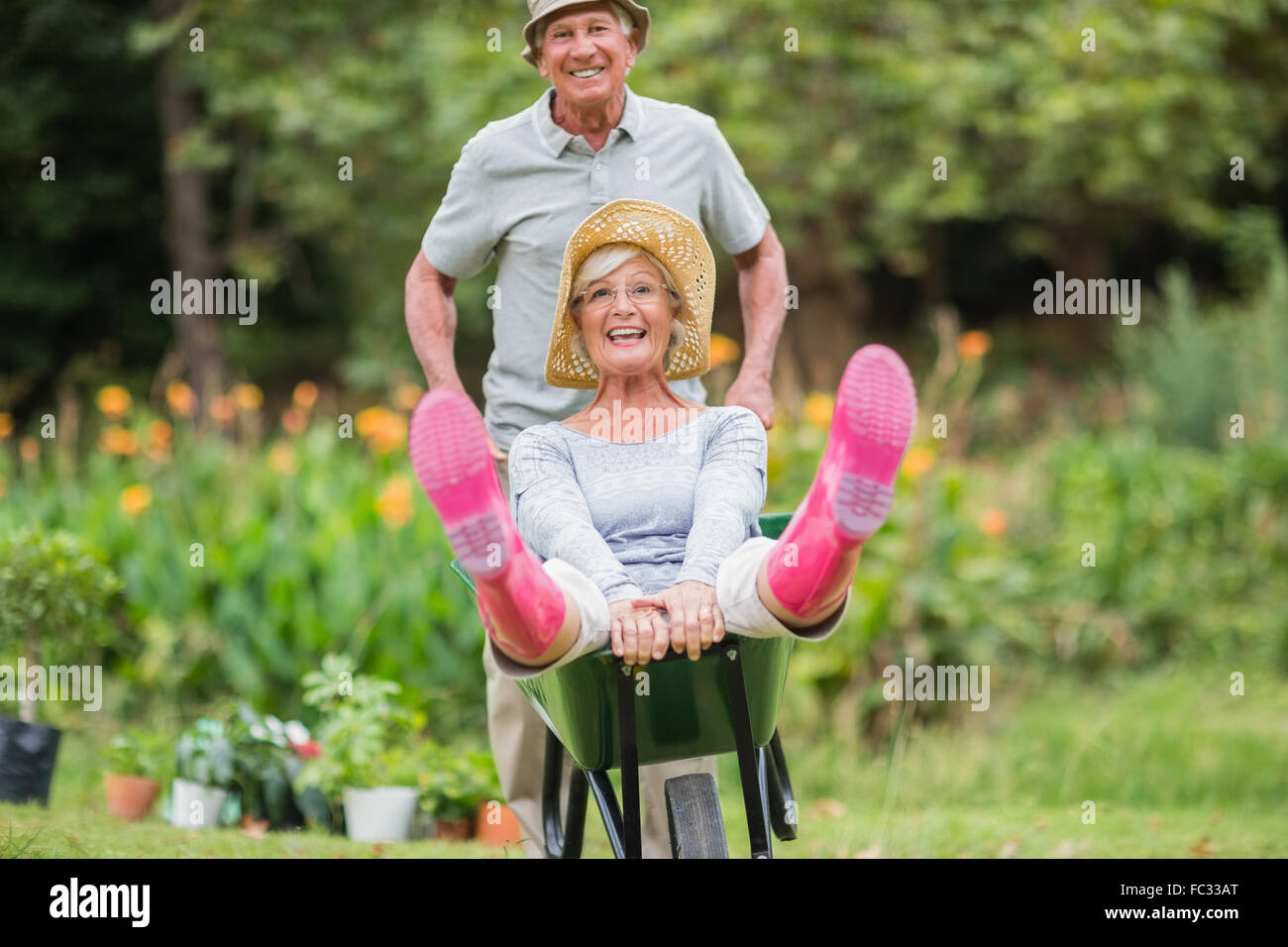 Happy senior couple playing with a wheelbarrow Stock Photo - Alamy