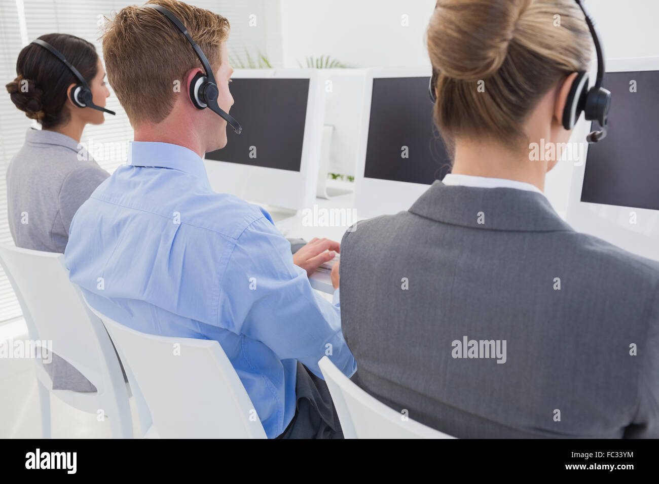 Business team working on computers and wearing headsets Stock Photo - Alamy