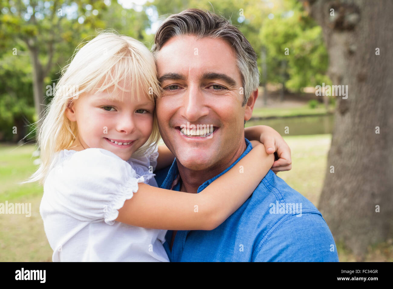 Happy father smiling at camera with his daughter Stock Photo - Alamy