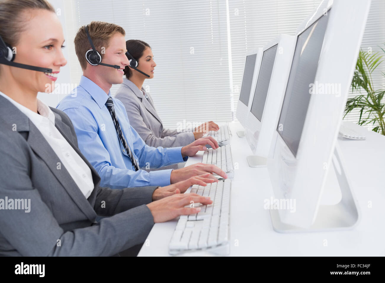 Business team working on computers and wearing headsets Stock Photo - Alamy