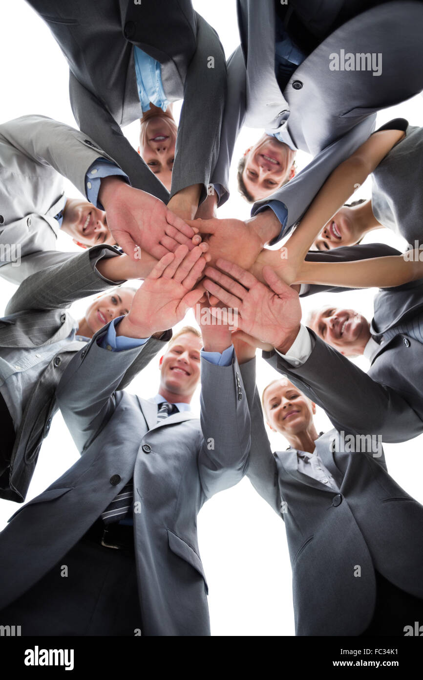 Smiling business team standing in circle hands together Stock Photo - Alamy
