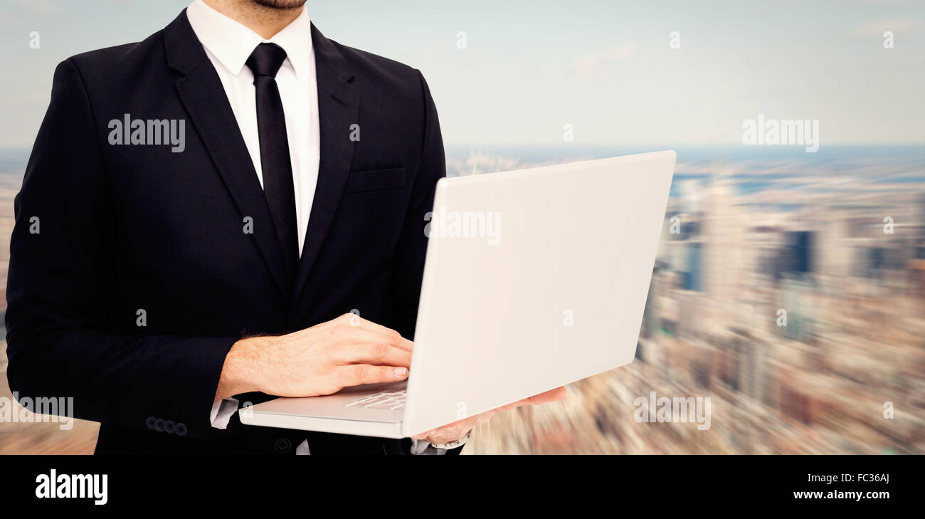 Composite image of mid section of a businessman using laptop Stock ...