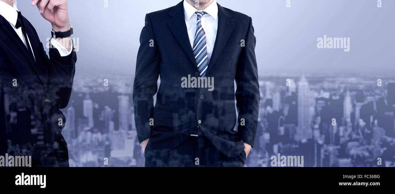 Composite image of smiling businessman standing with hands in pockets ...