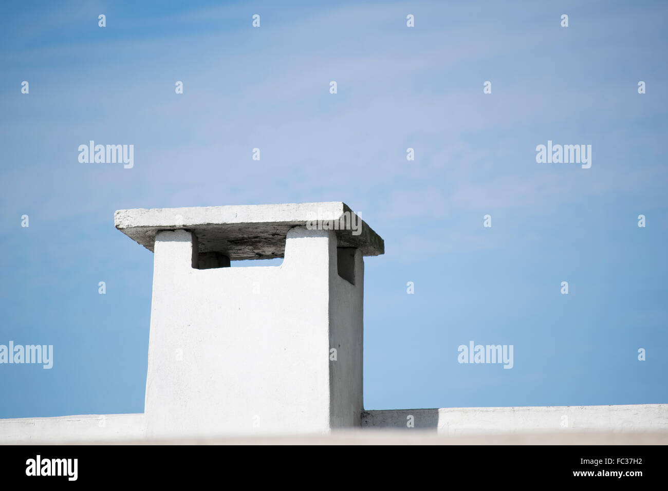 Exterior view of concrete white chimney against clean blue sky ...