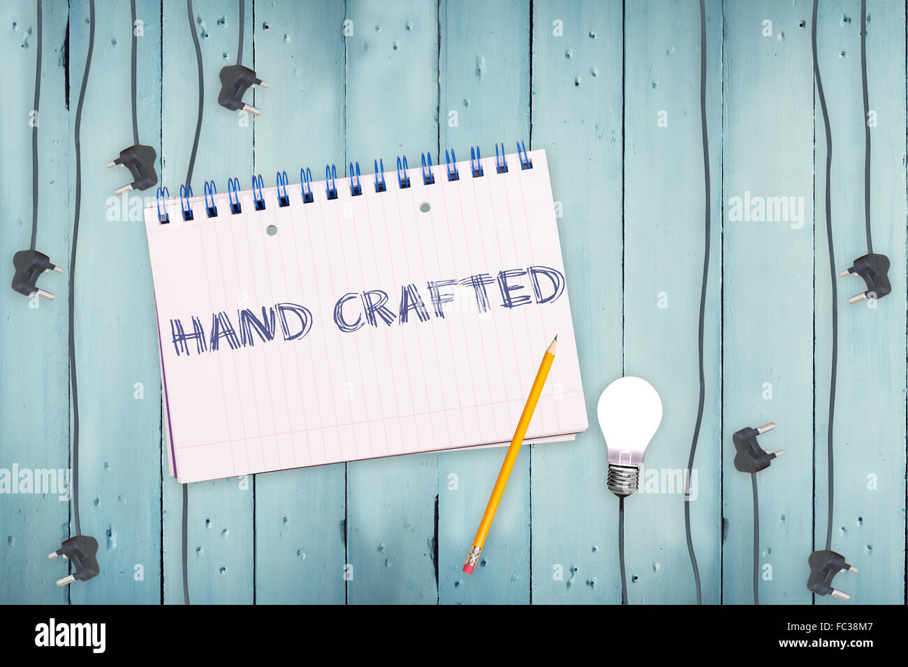 Hand crafted against notepad and plug on wooden background Stock Photo ...