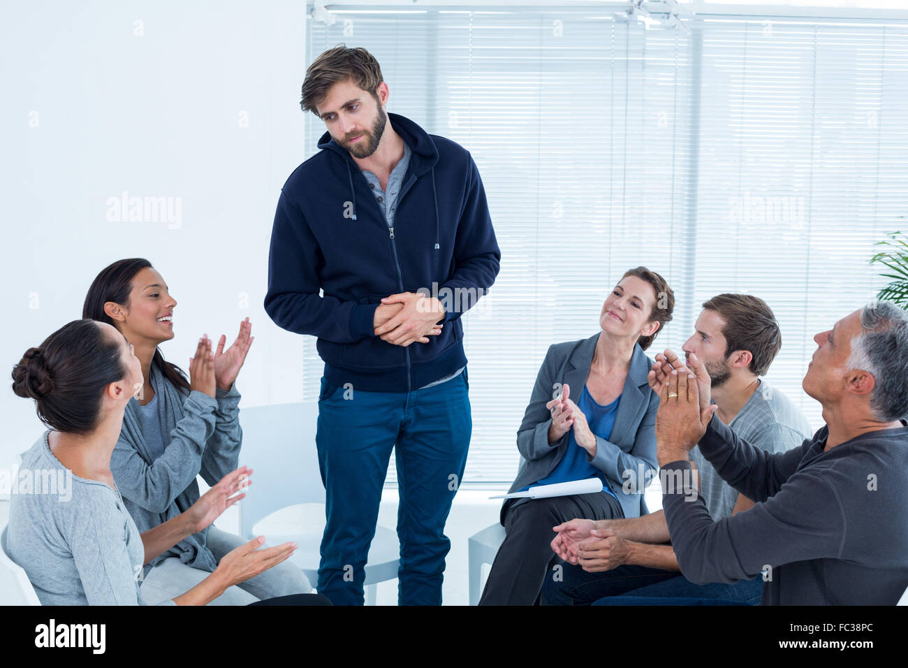 Rehab group applauding delighted man standing up Stock Photo - Alamy