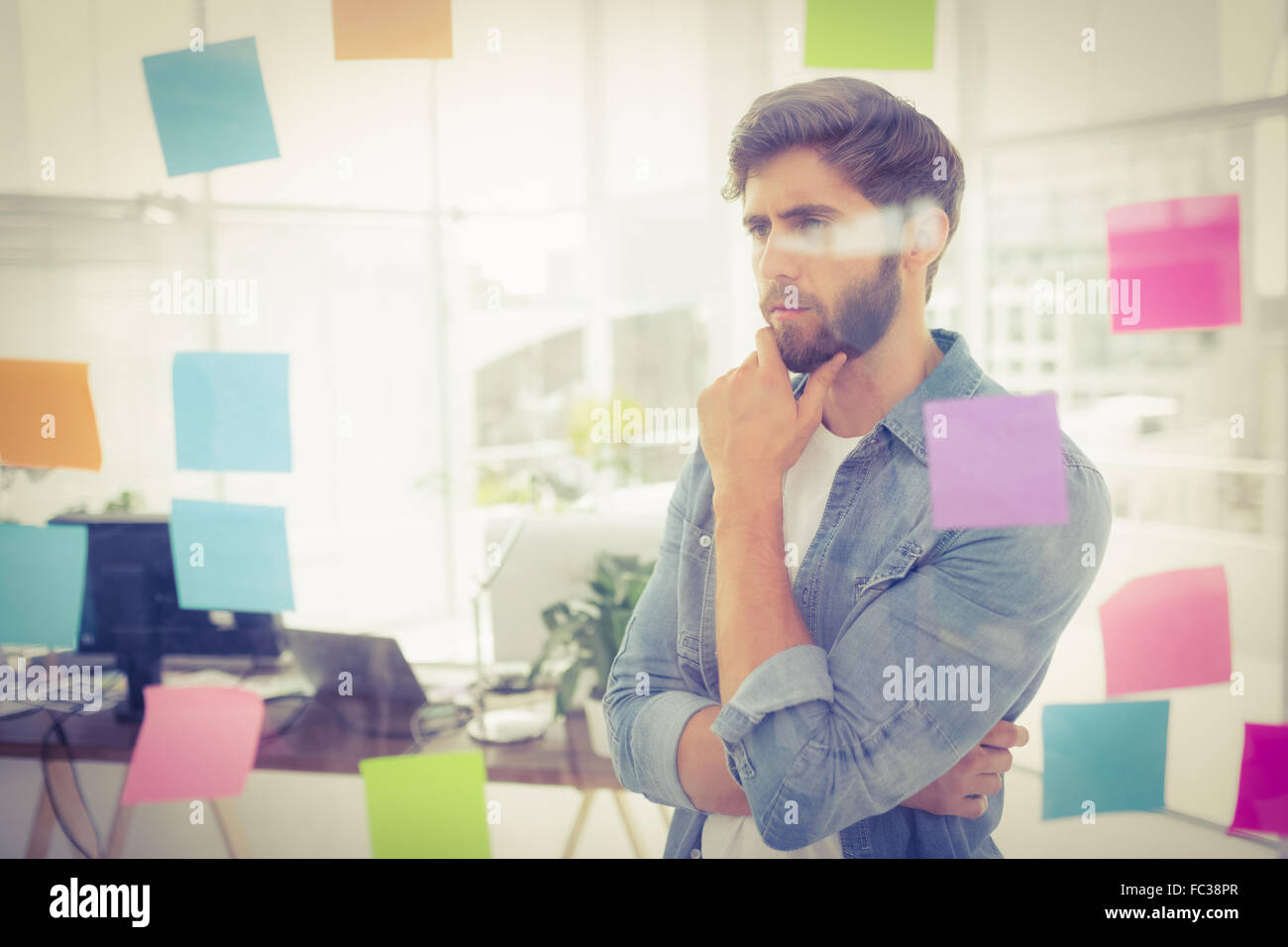Puzzled businessman looking post its on the wall Stock Photo - Alamy