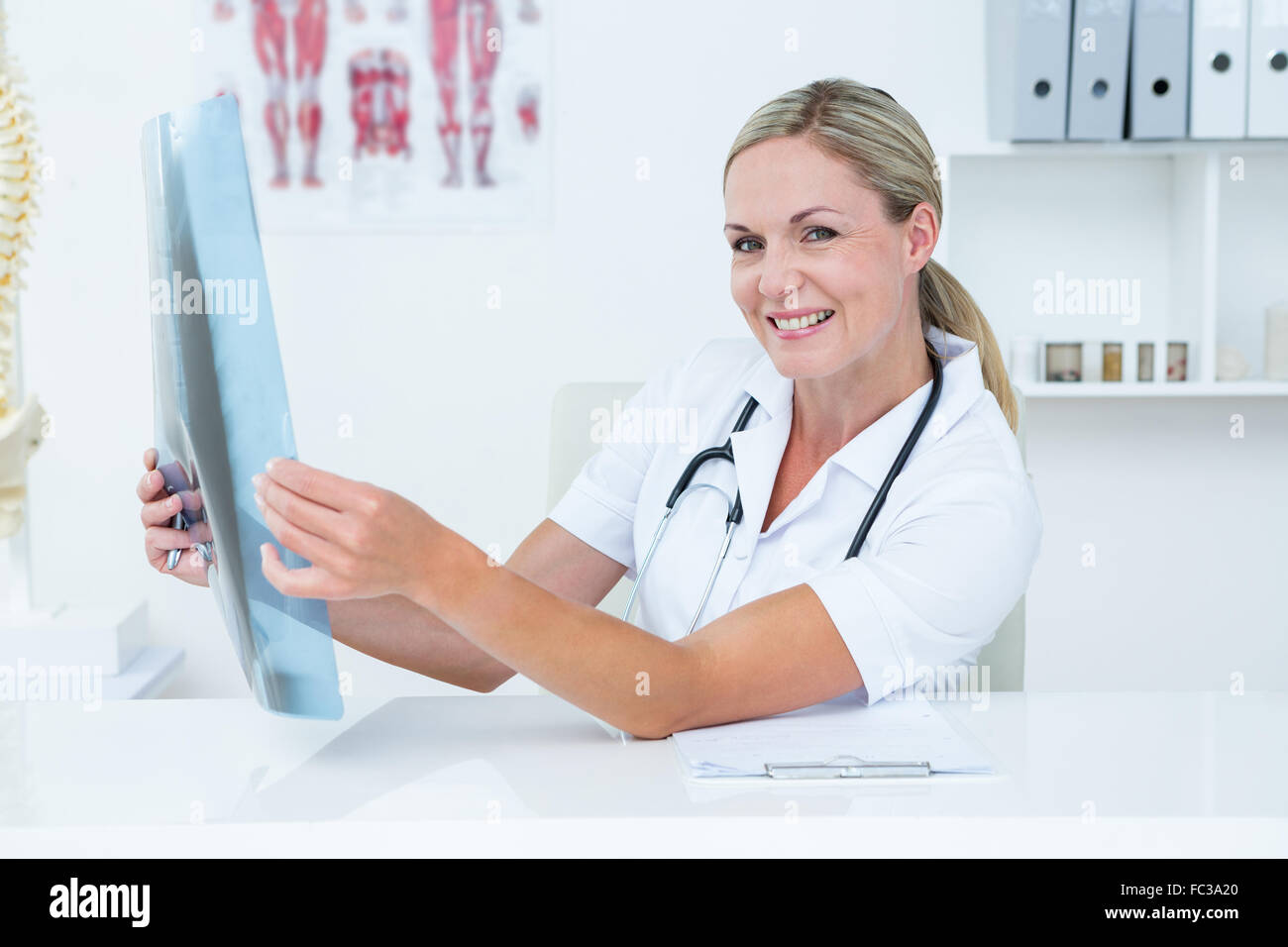 Smiling doctor looking at camera and holding X-Rays Stock Photo - Alamy