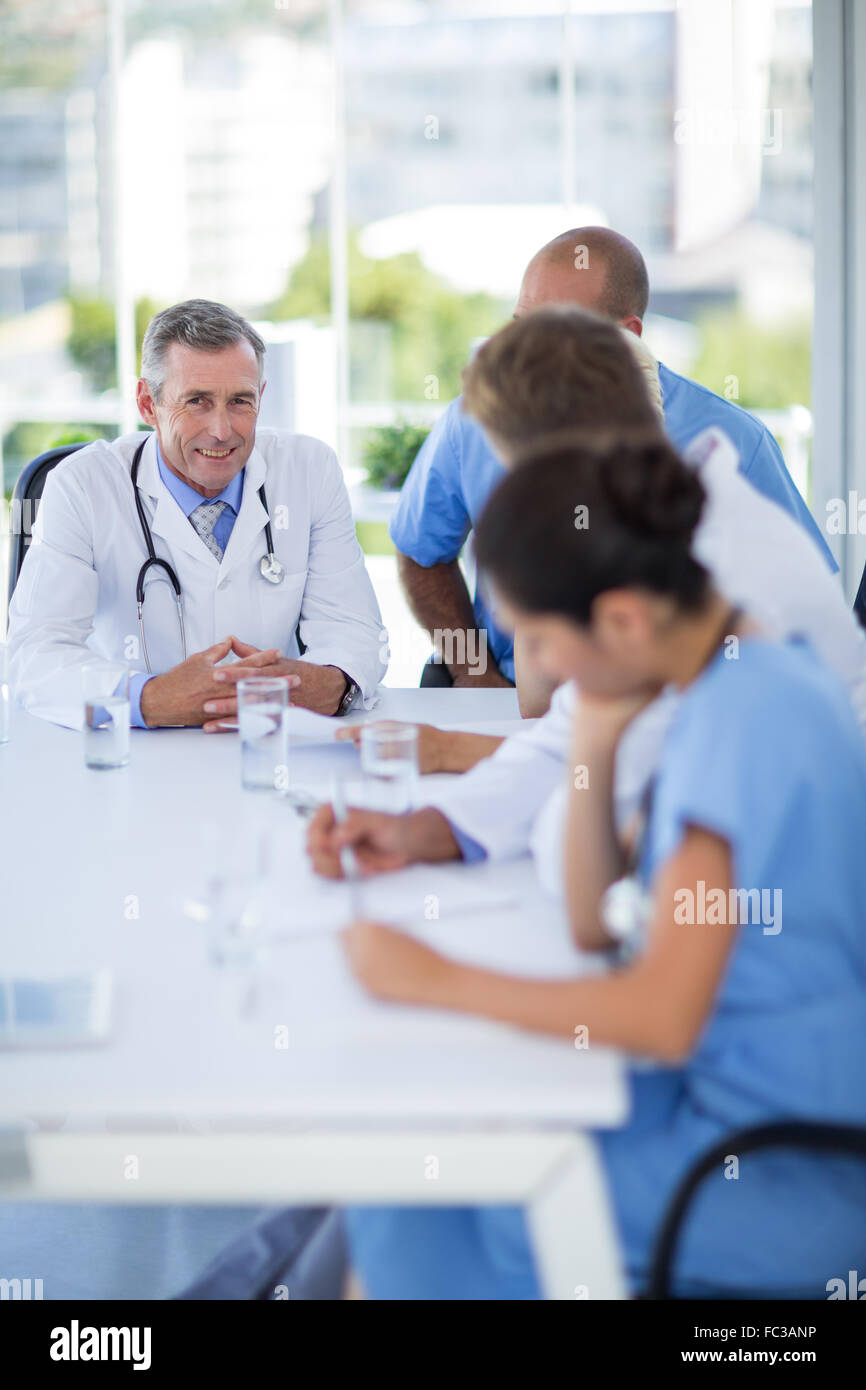 Happy doctor smiling at camera while his colleagues works Stock Photo ...
