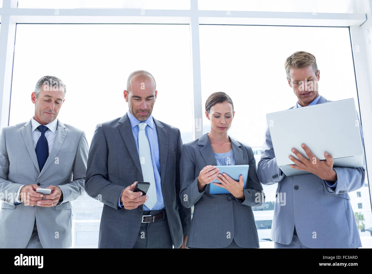Business colleagues using their multimedia devices Stock Photo - Alamy